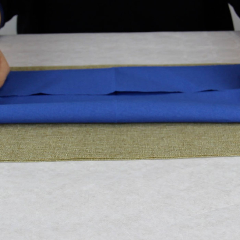 Réaliser un pliage de serviette en forme de robe