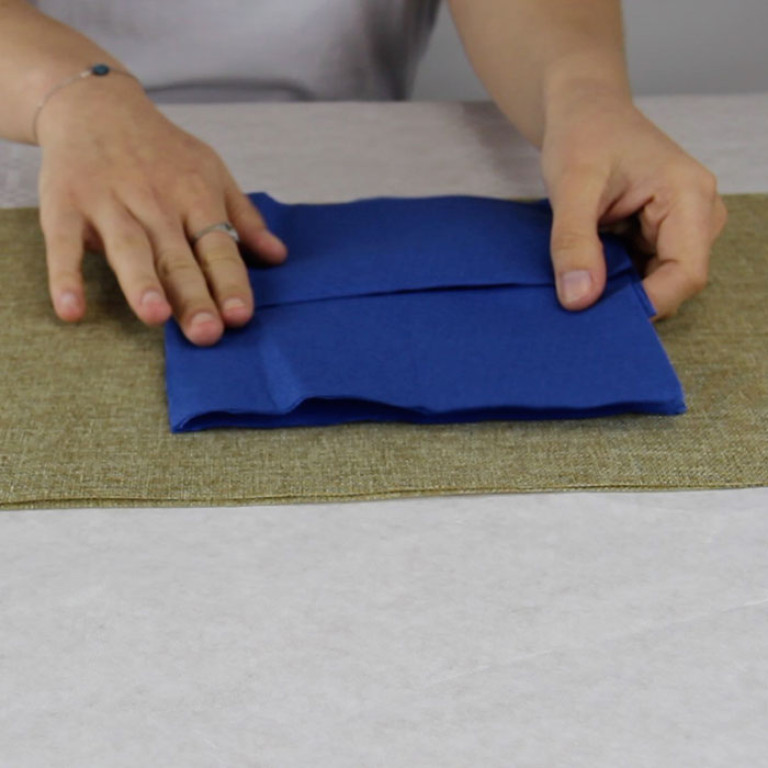 Réaliser un pliage de serviette en forme de robe