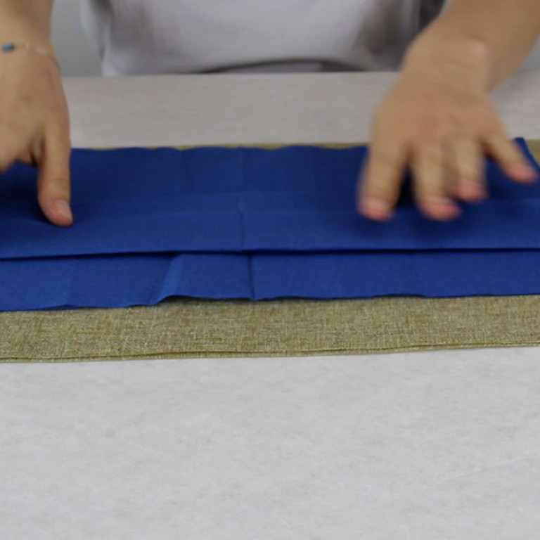 Réaliser un pliage de serviette en forme de robe