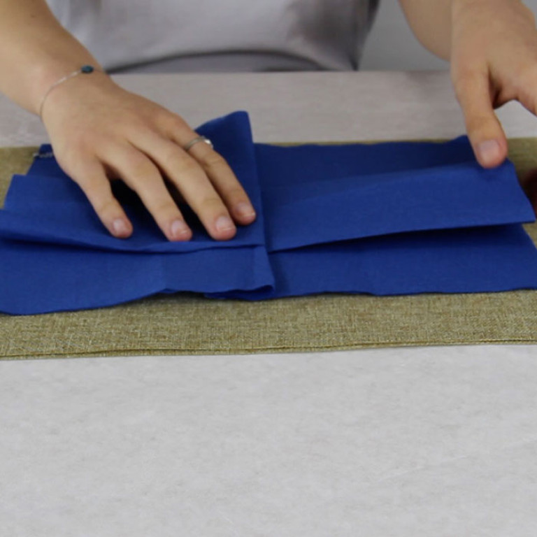 Réaliser un pliage de serviette en forme de robe