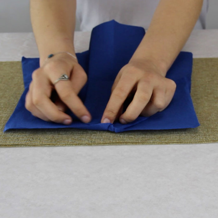 Réaliser un pliage de serviette en forme de robe