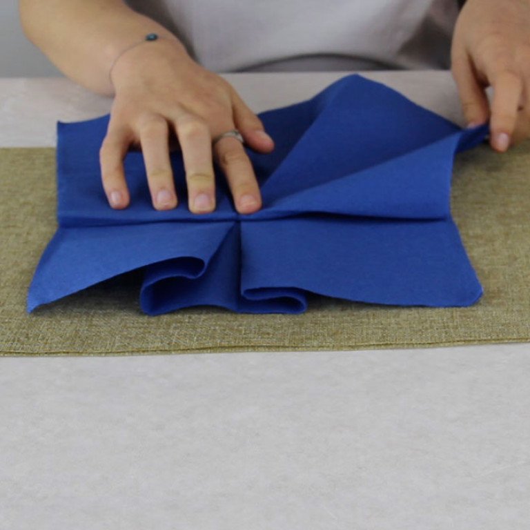 Réaliser un pliage de serviette en forme de robe