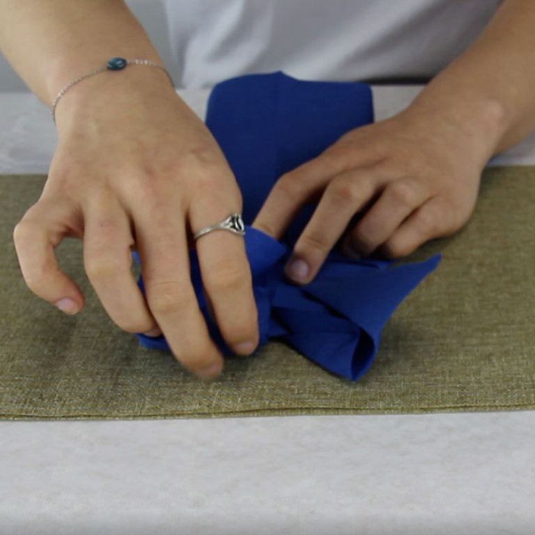 Réaliser un pliage de serviette en forme de robe